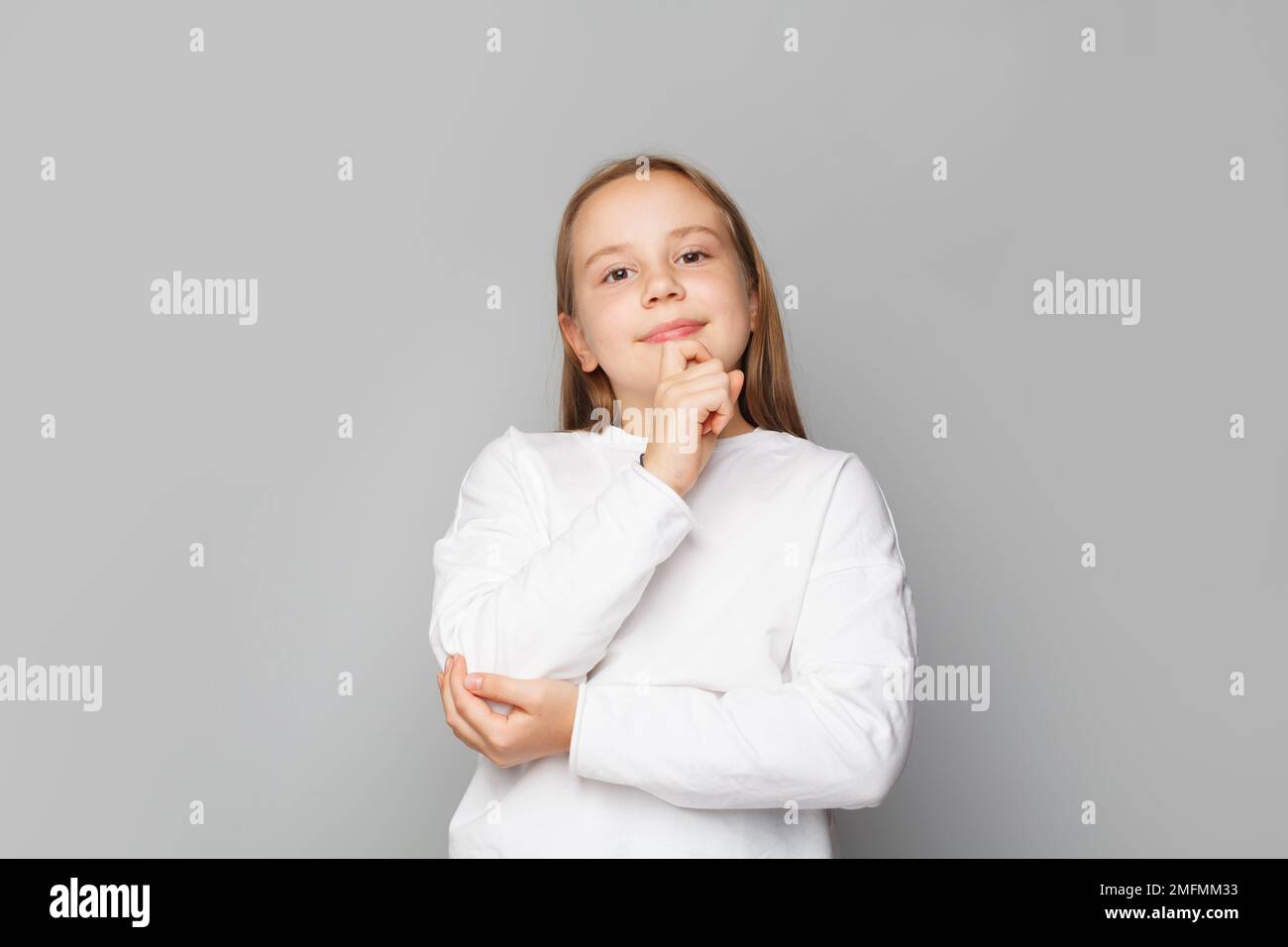 Cheerful young child girl thinking. Idea, brainstorming and education ...