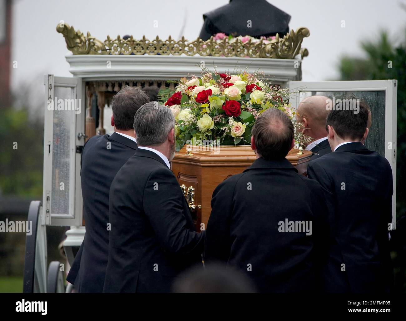 The bearer party, including father Tim Edwards (left) lift the coffin ...