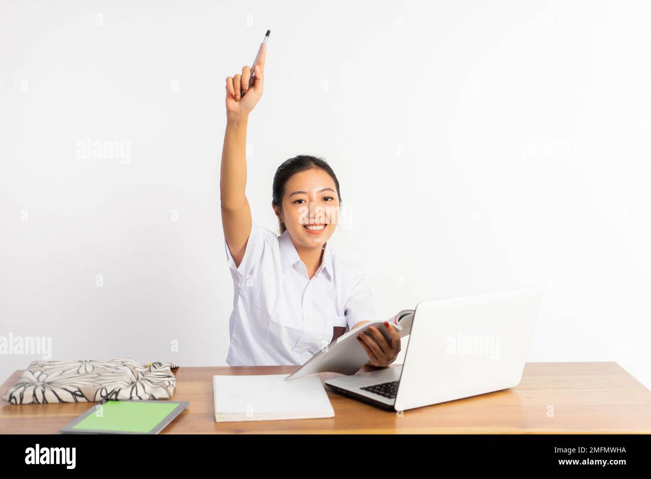 high school girl at desk pointing finger while using laptop Stock Photo ...