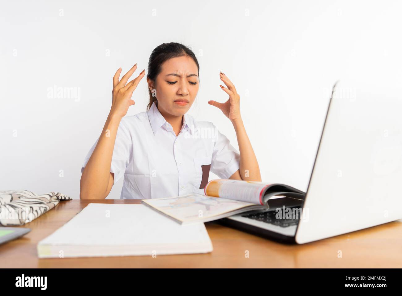 high school girl at desk using laptop with dizzy expression Stock Photo ...