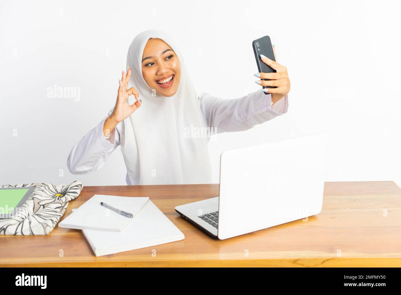 veiled school student at desk with laptop while taking selfie Stock ...