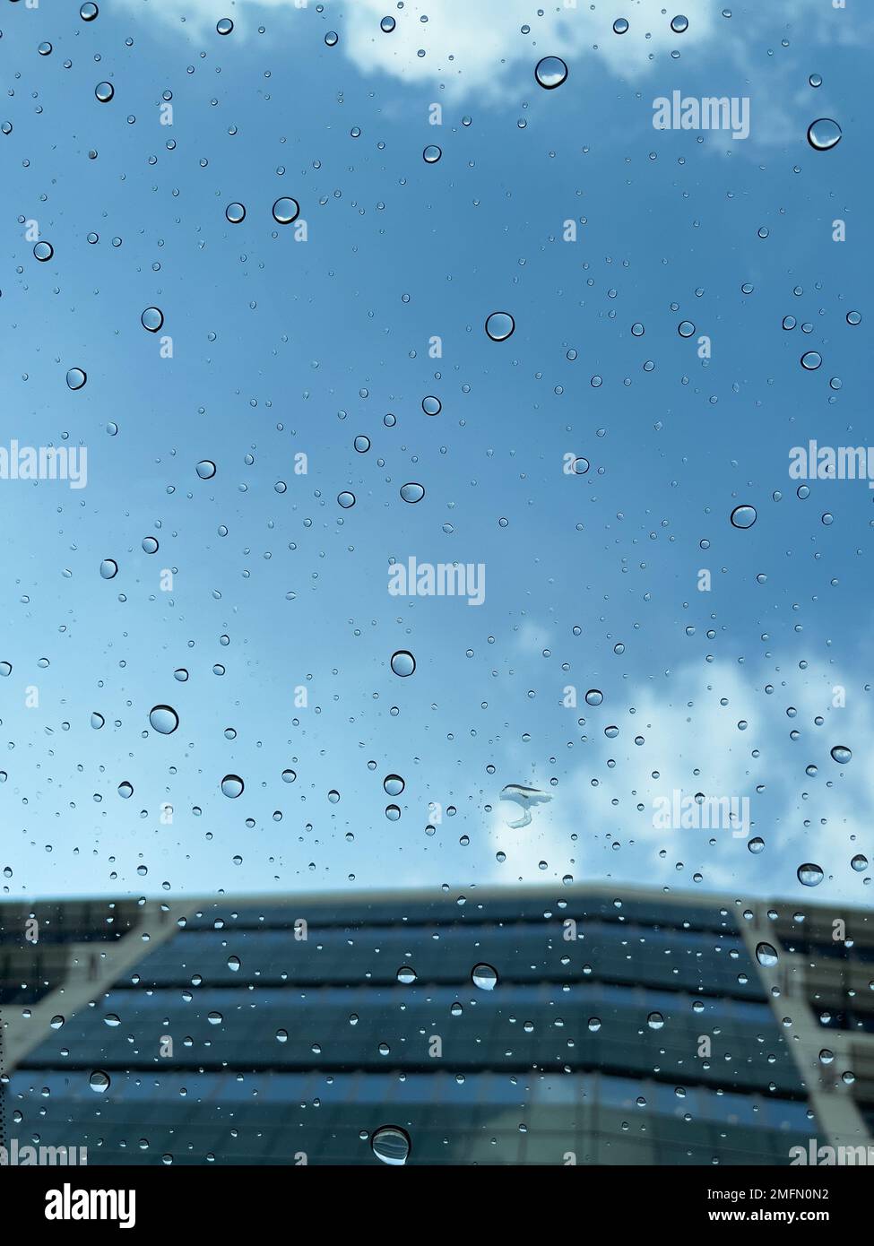 Selective focus on the rain droplets on the glass sunroof of a vehicle ...