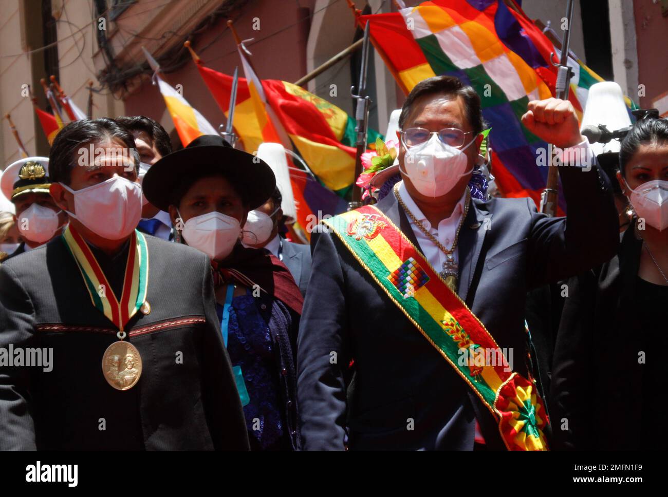 Bolivia's new President Luis Arce, right, raises his fist as he walks beside Vice President ...