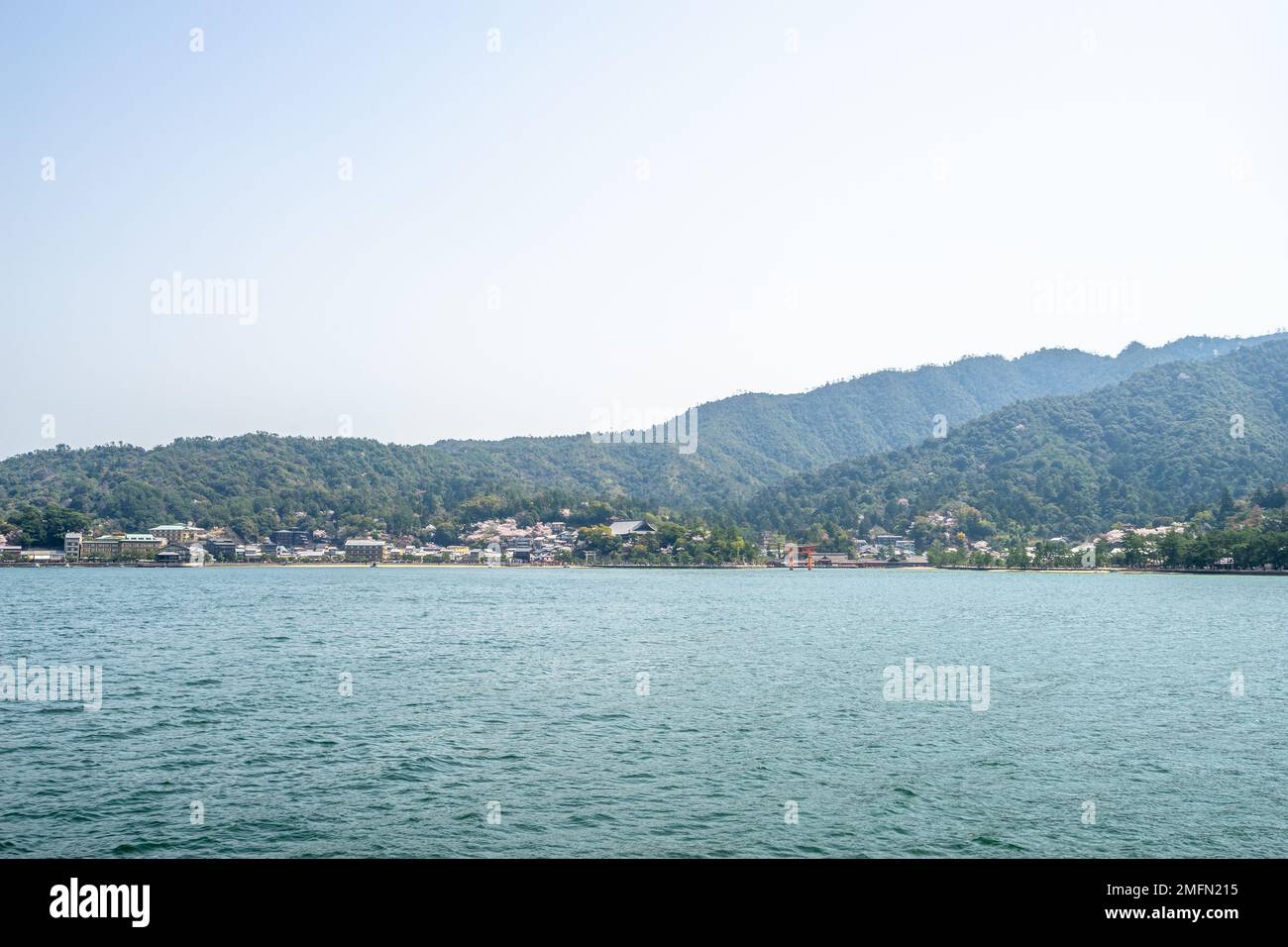 Beautiful scenic of Itsukushima shrine with green mountain behind in ...