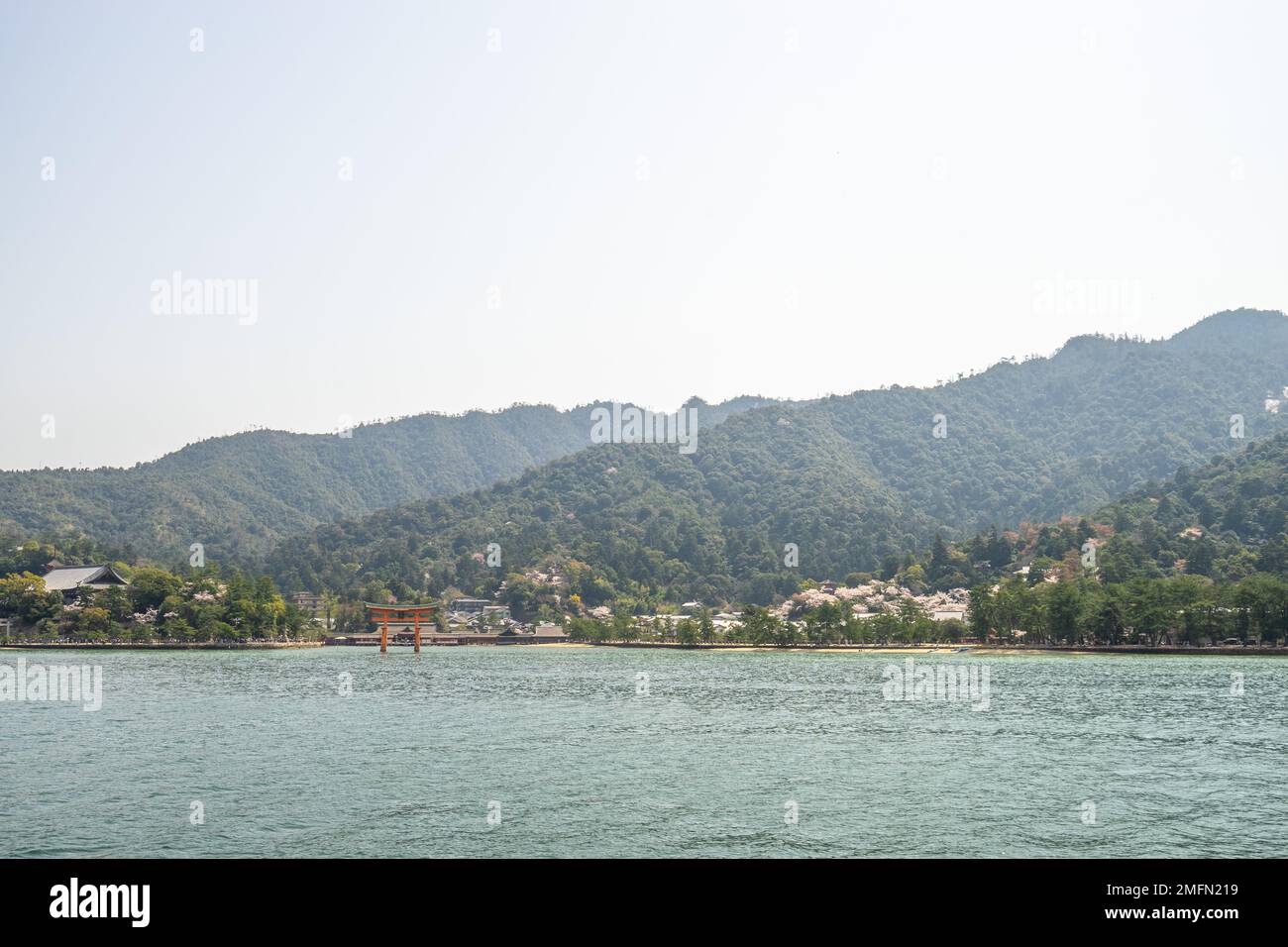 Beautiful scenic of Itsukushima shrine with green mountain behind in ...