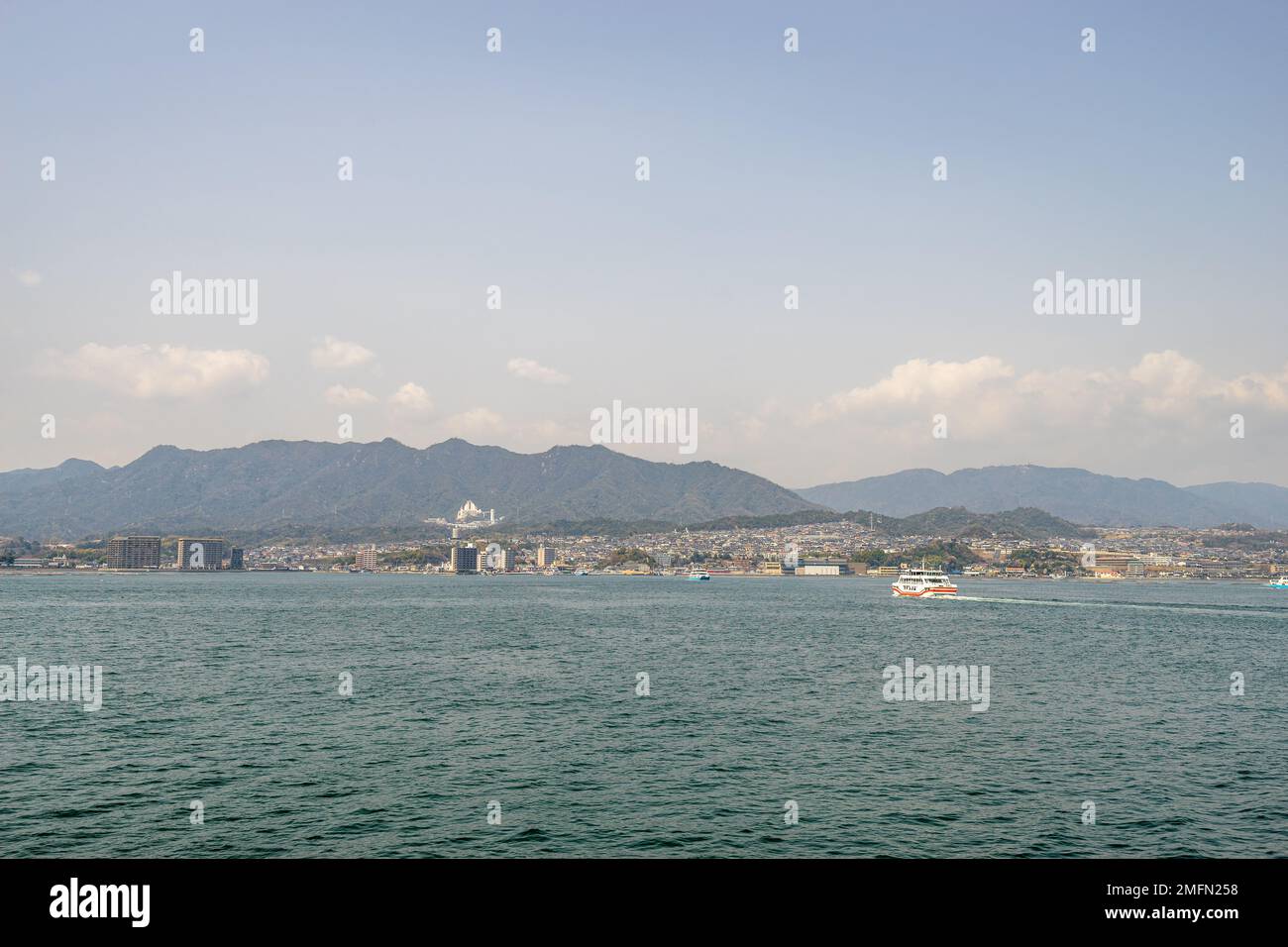 Beautiful landscape of Miyajima city with ferry boat from the island in ...