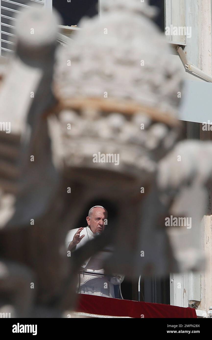 Pope Francis, seen through a marble statue, delivers his blessing ...