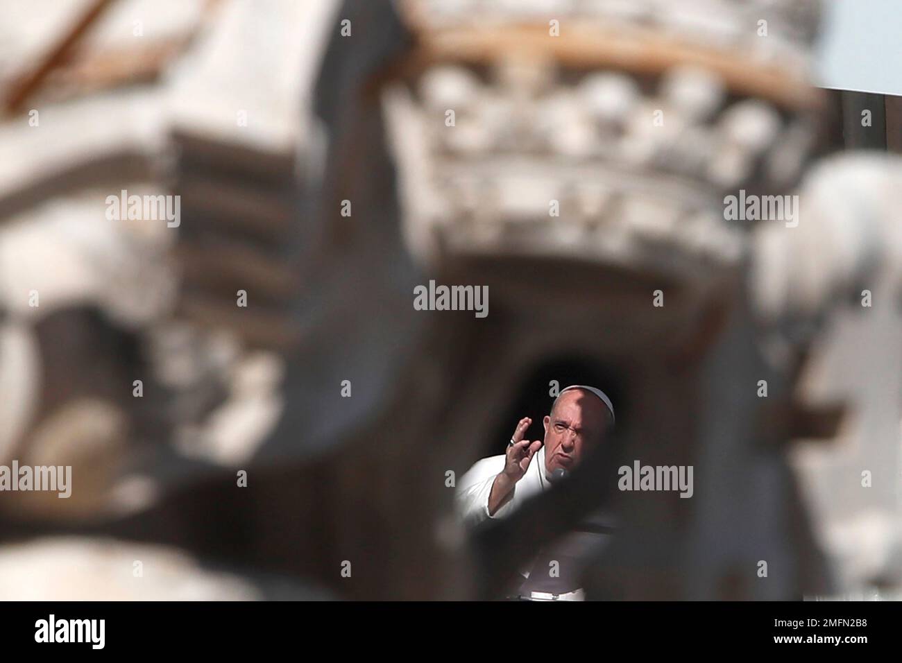 Pope Francis, seen through a marble statue delivers his blessing during ...