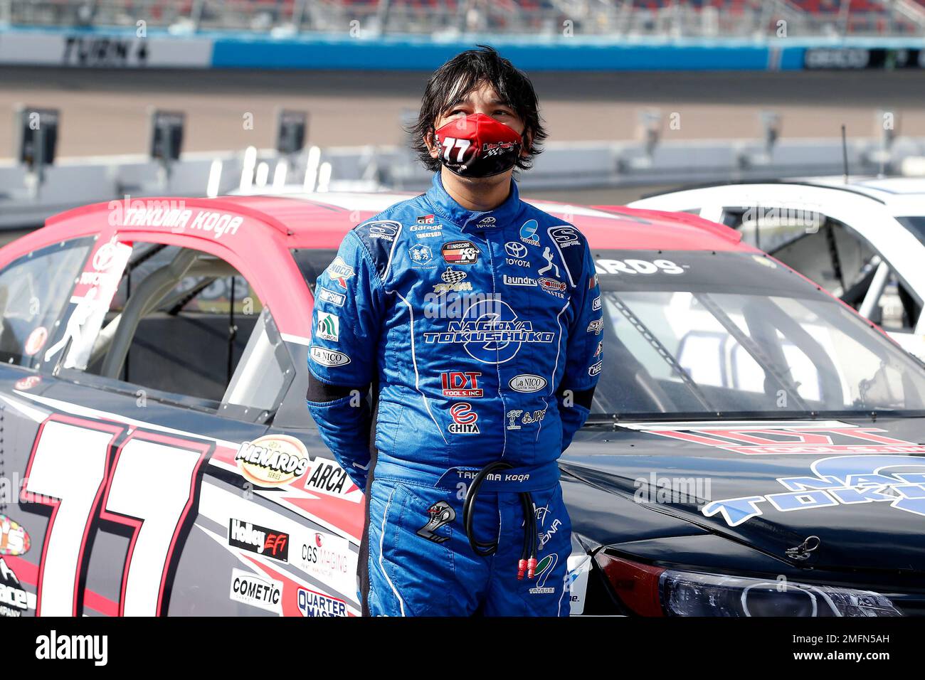 Takuma Koga, of Japan, stands next to his race car on pit road prior to ...