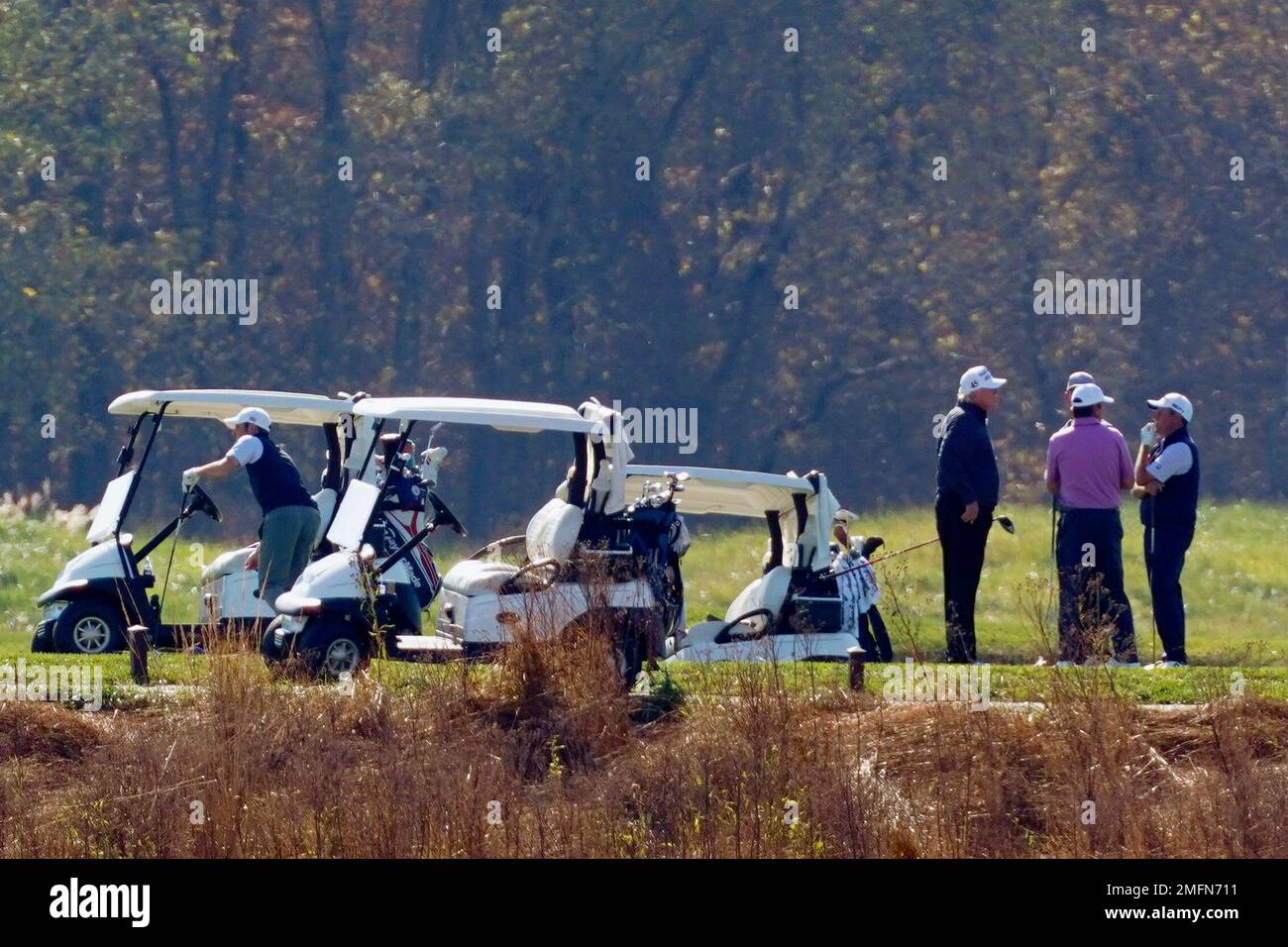 President Donald Trump listens as he participates in a round of golf at ...