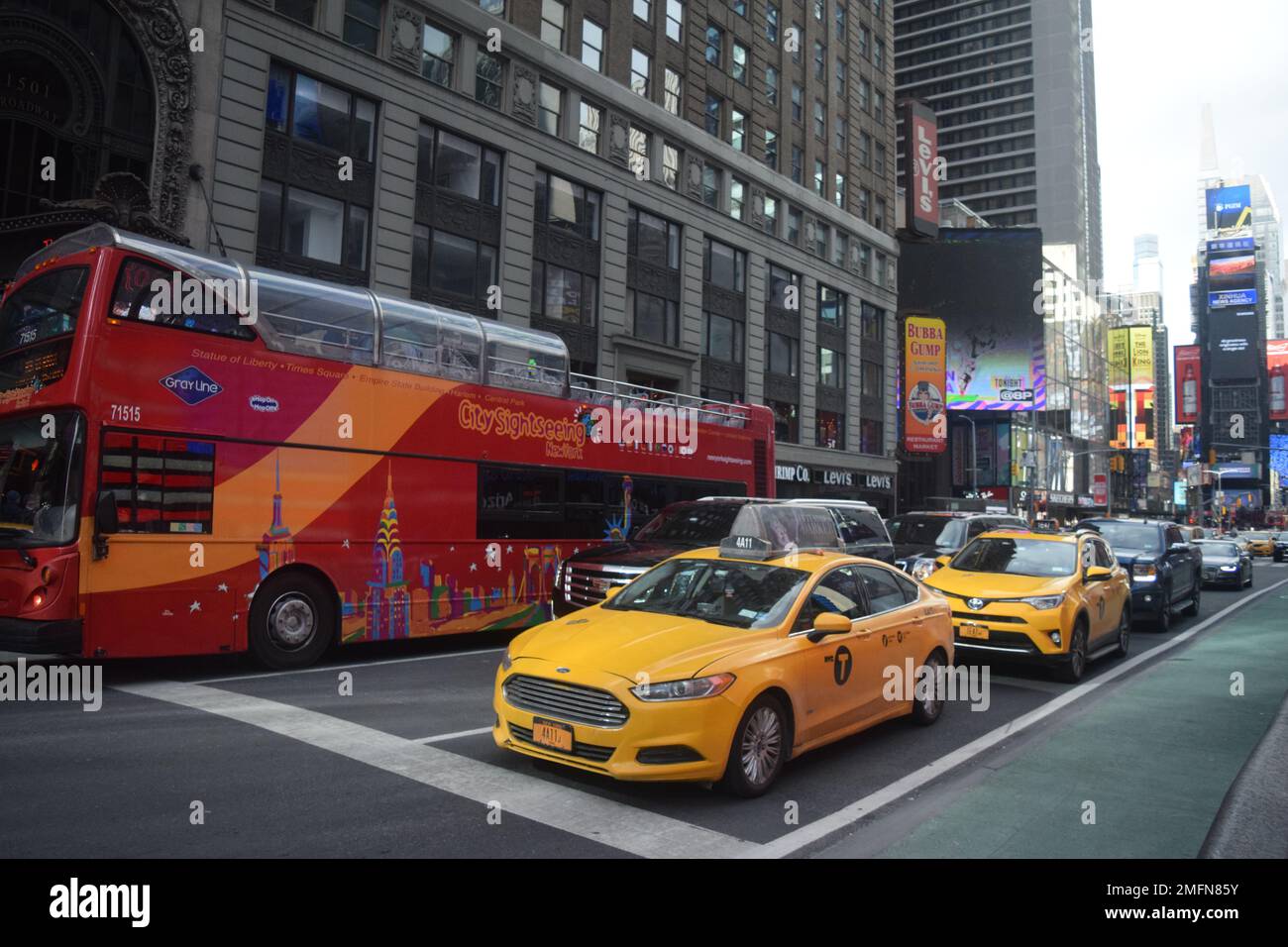 yellow taxi and red bus in times square in manhattan in new york | the ...