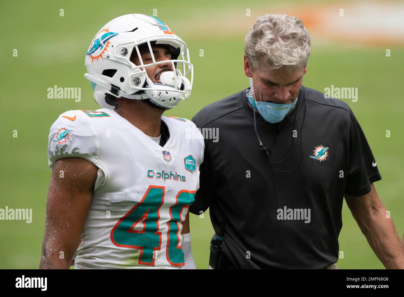 Miami Dolphins cornerback Nik Needham (40) walks of the field in pain ...