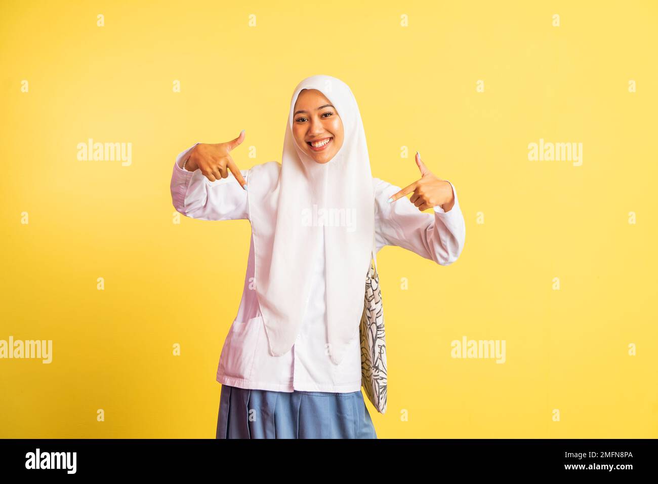 happy veiled student girl with two fingers pointing down Stock Photo ...