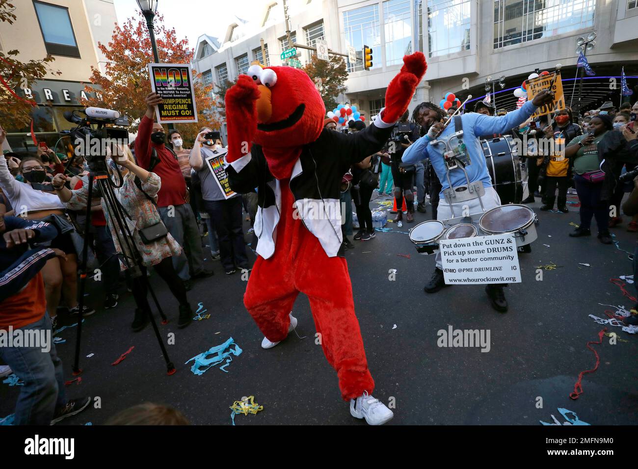 A demonstrator dressed as Elmo, a character from The Muppets, dances ...