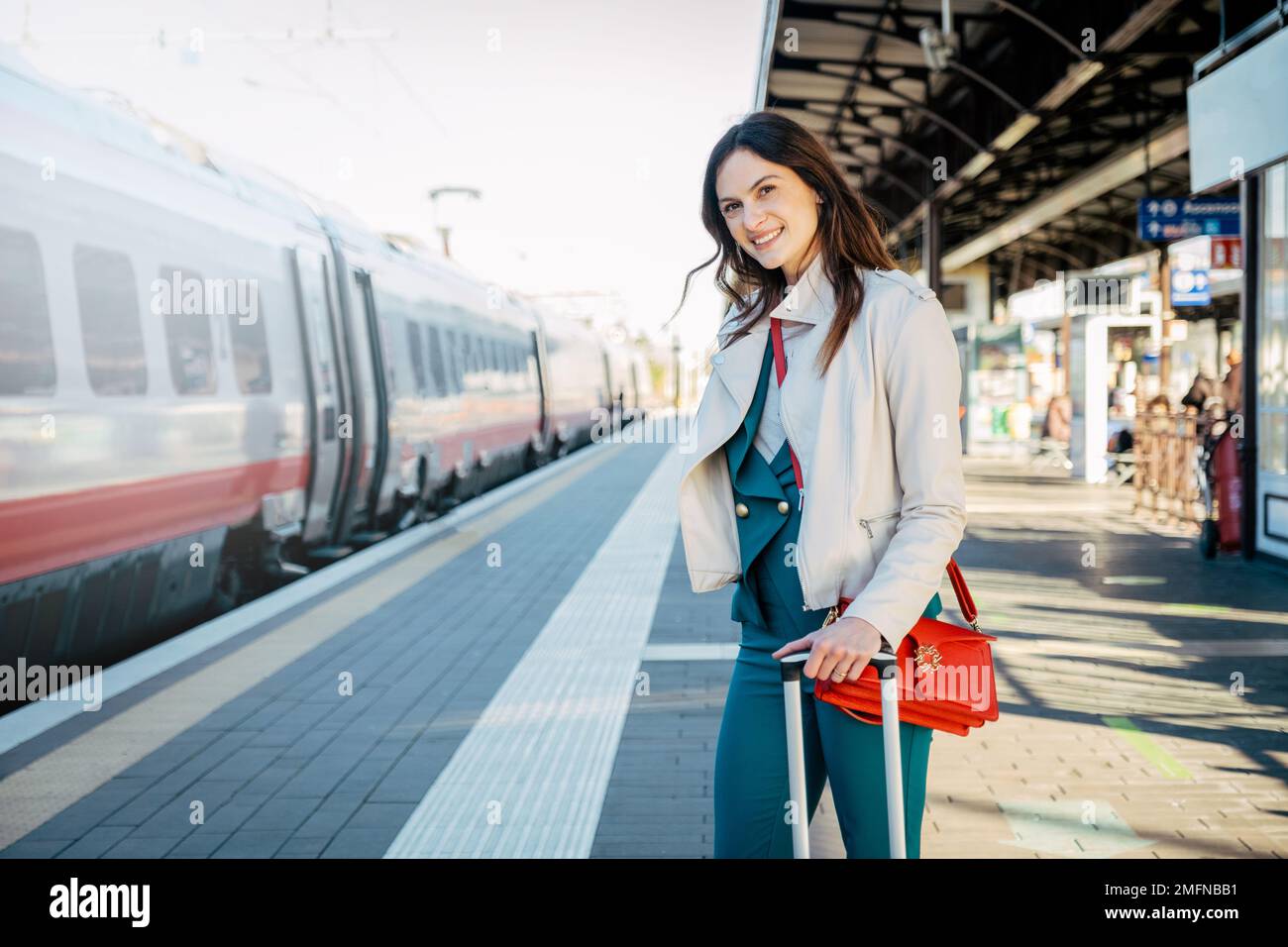 Portrait of a business woman commuter walking in a train station or ...