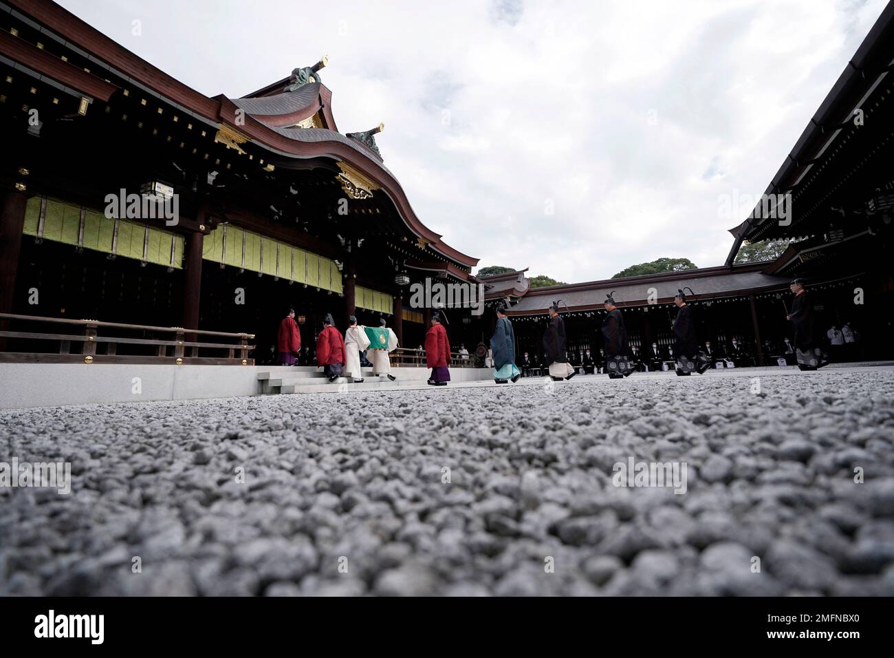 Shinto priests in ritual clothing perform a ceremonial rite to mark the ...