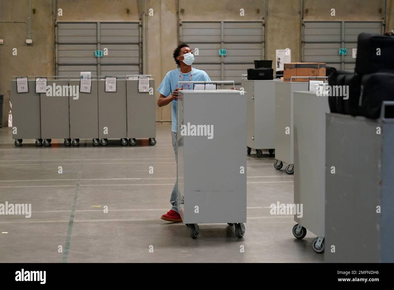 A county election worker moves polling place equipment at the Clark ...