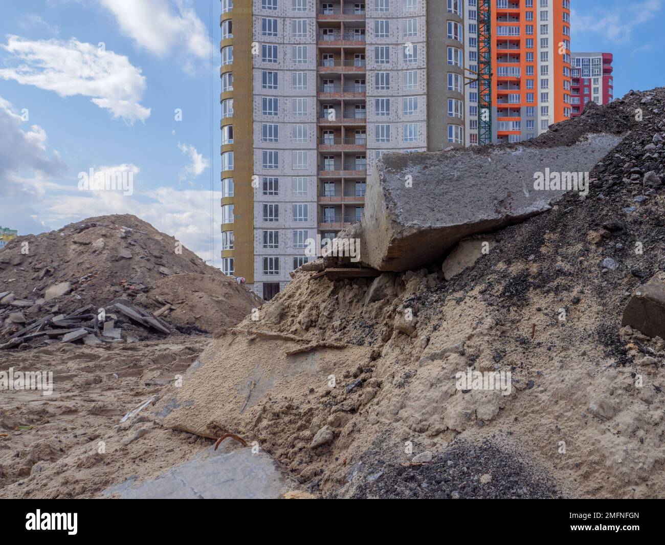 A building site with piles of sand and huge concrete block in the ...