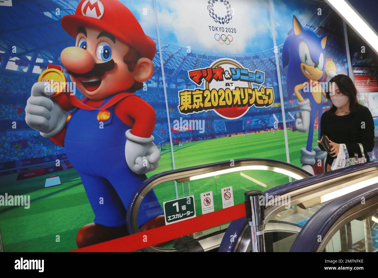 A shopper standing on an escalator passes by the Super Mario of ...