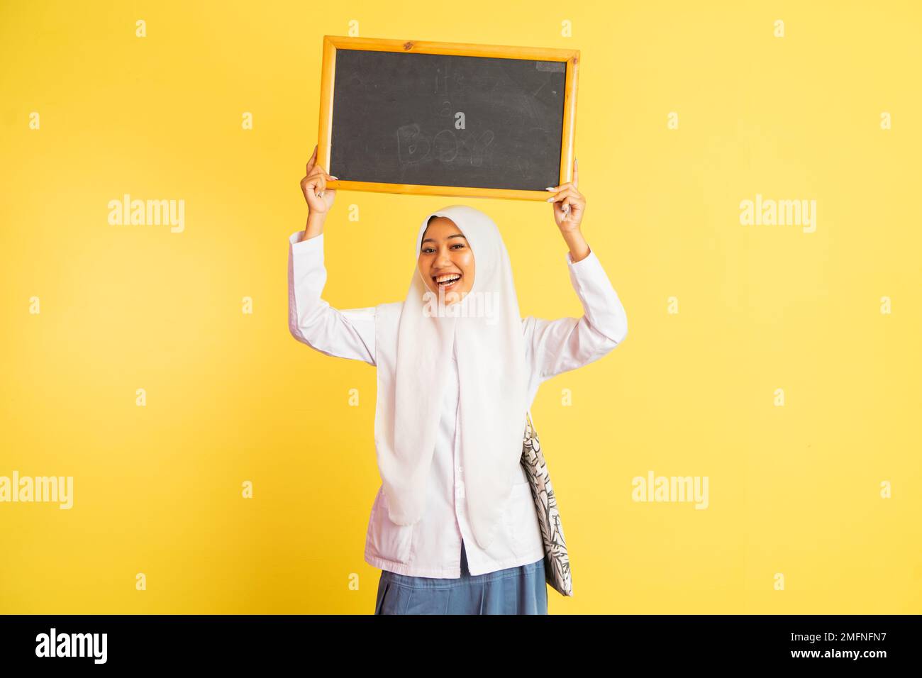 girl in school uniform in veil carrying black chalkboard up Stock Photo ...