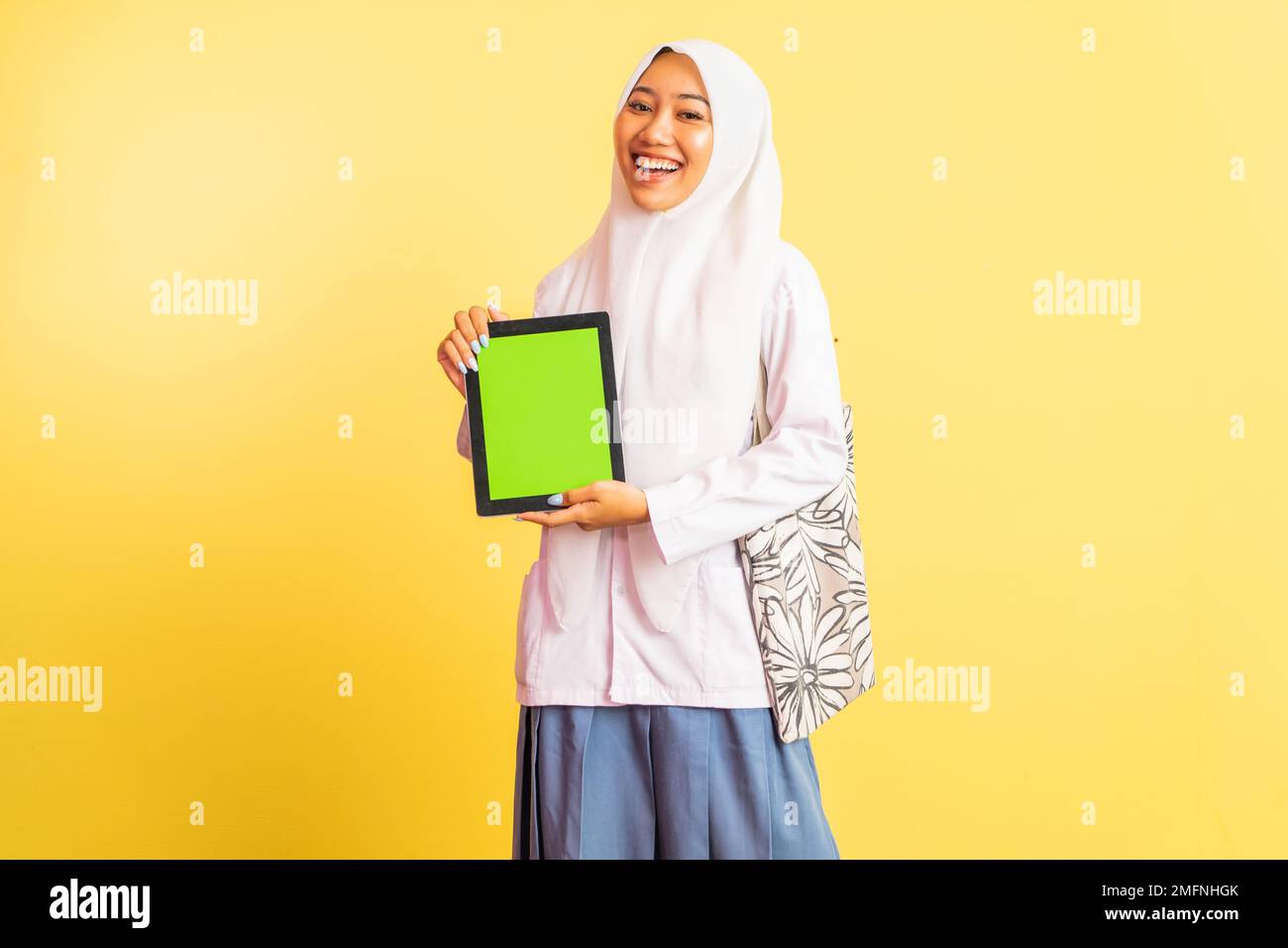 veiled school student girl showing blank screen of a tablet Stock Photo ...