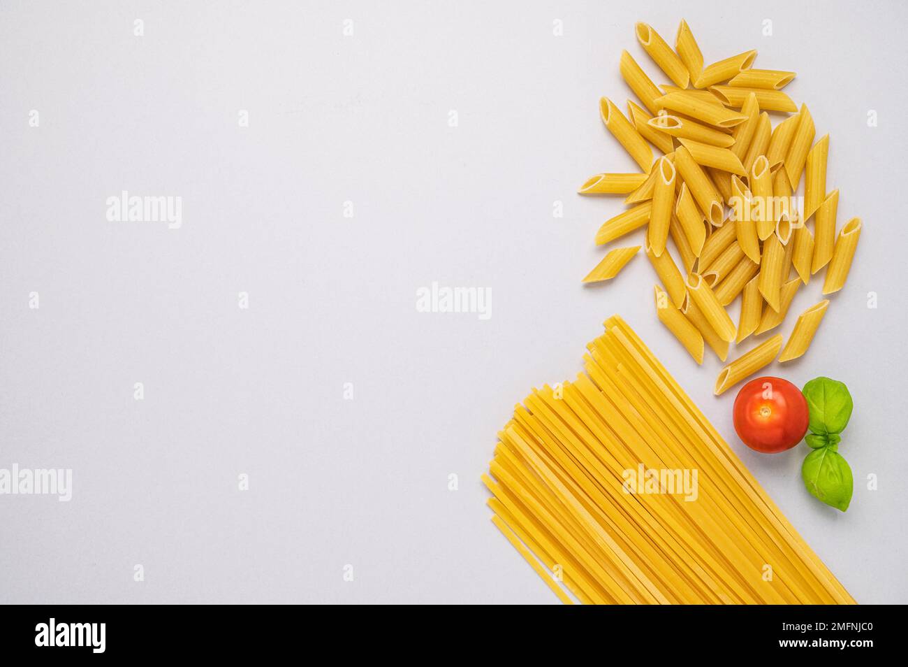 Different pasta types on the gray background. Spaghetti and penne with ...