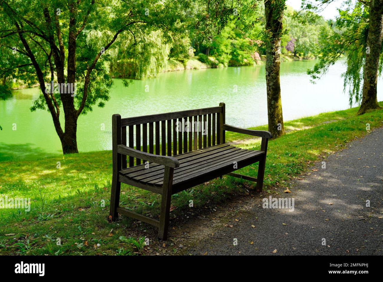 green river with classic wooden bench in pathway France Stock Photo - Alamy