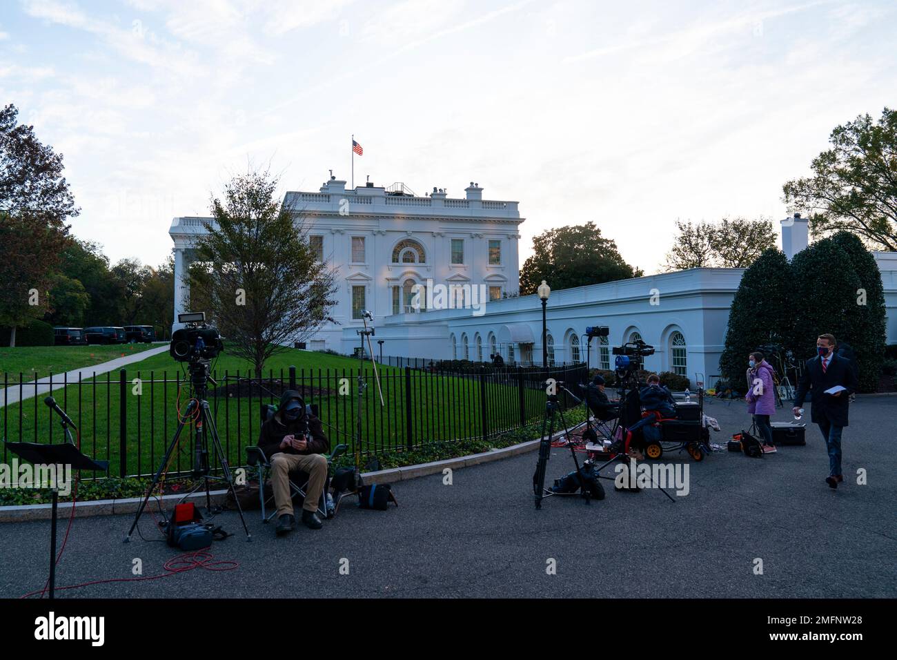 Media crews are set up as the sun rises behind the White House on ...