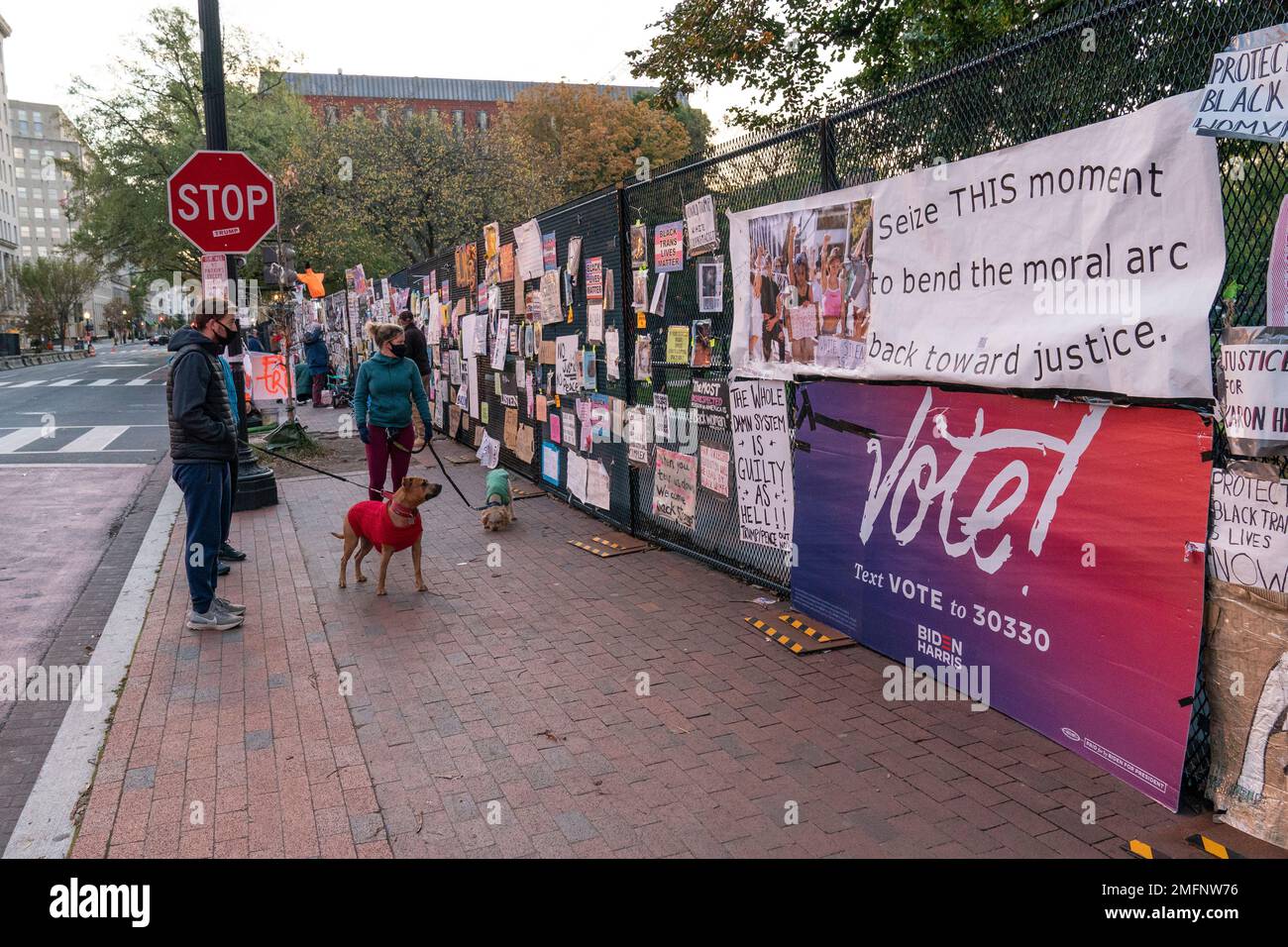 The anti-scaling fence around the White House is covered with signs on ...