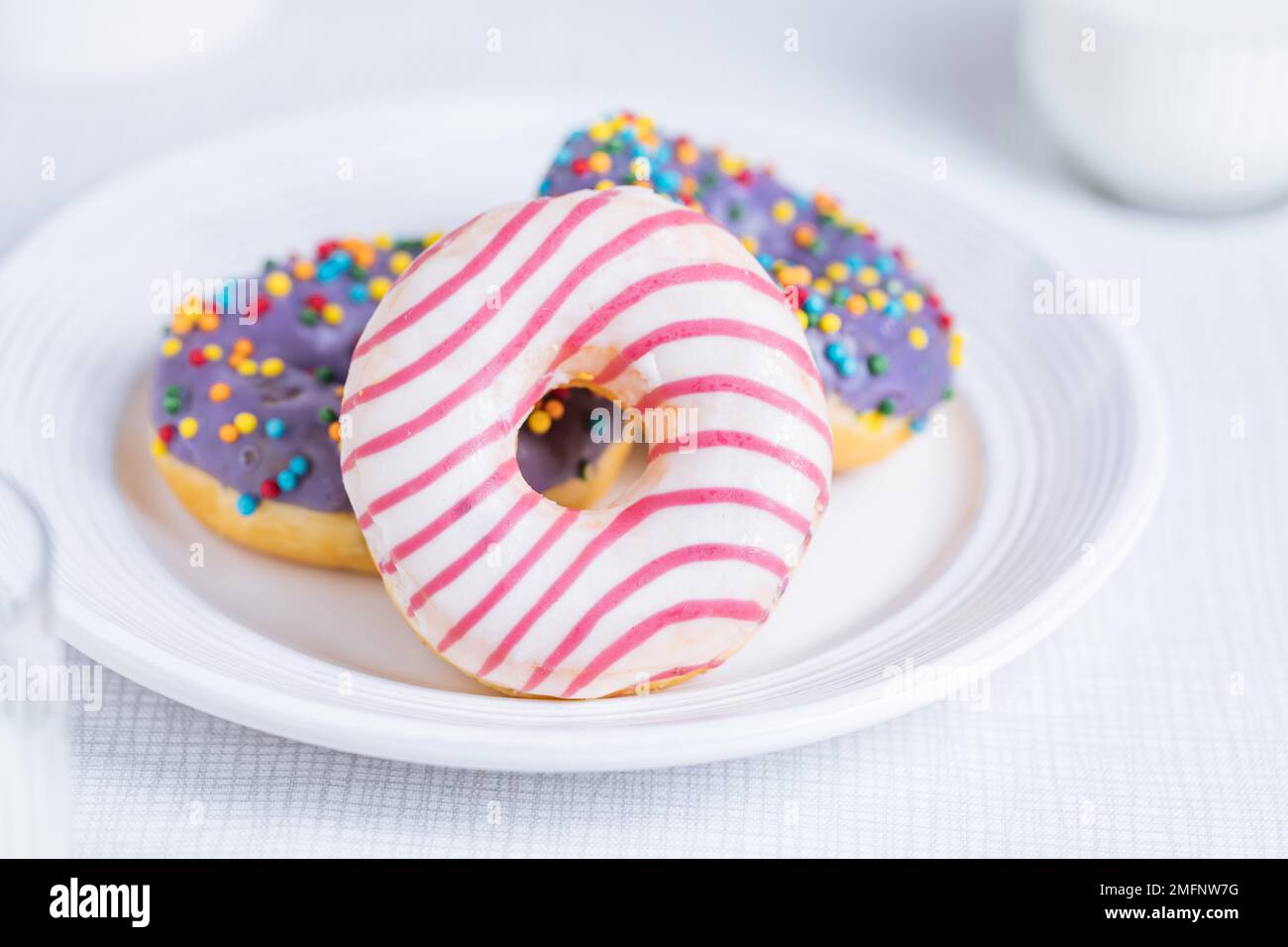 American donuts on white plate on bright background. Playful and ...