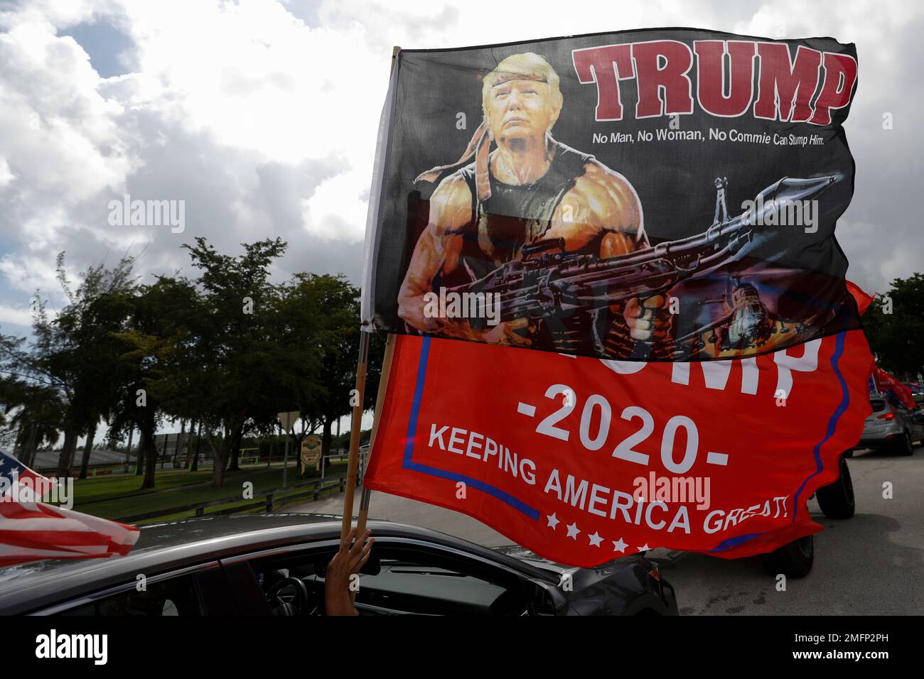 A supporter of President Donald Trump waves a flag depicting Trump as ...