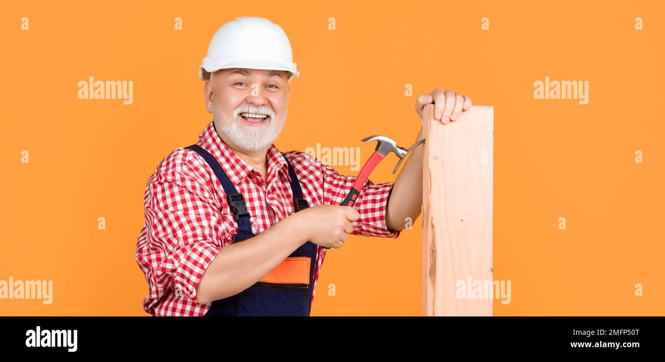 happy senior man woodworker in hard hat on yellow background Stock ...