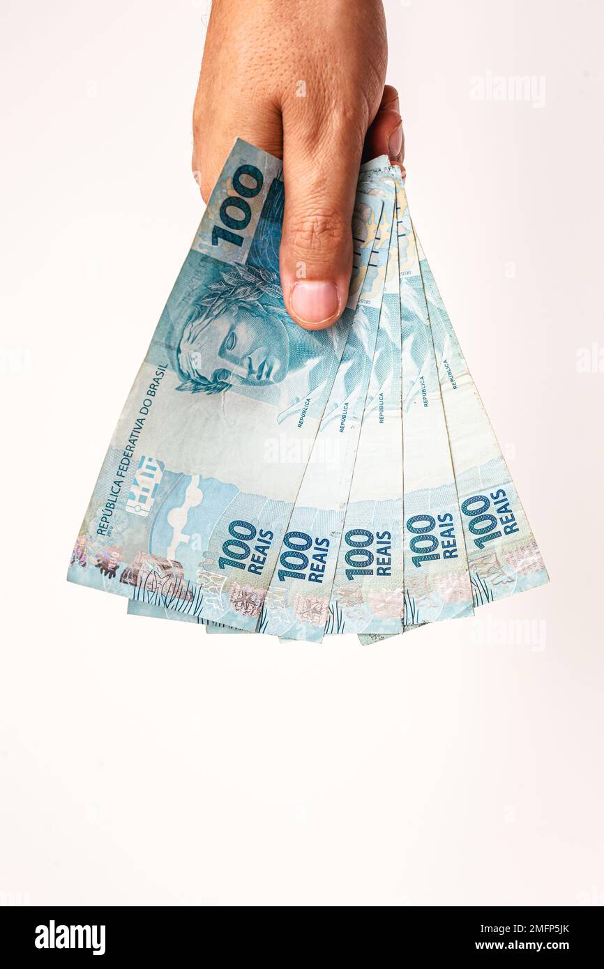 100 reais bills from Brazil, held by male hand on isolated white ...