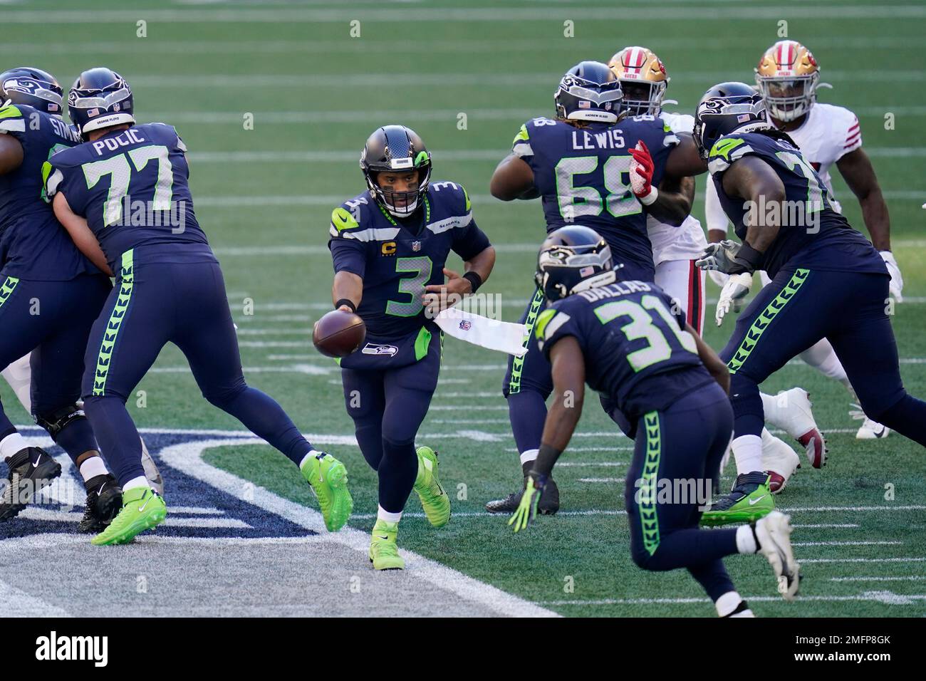 Seattle Seahawks quarterback Russell Wilson hands off to running back ...