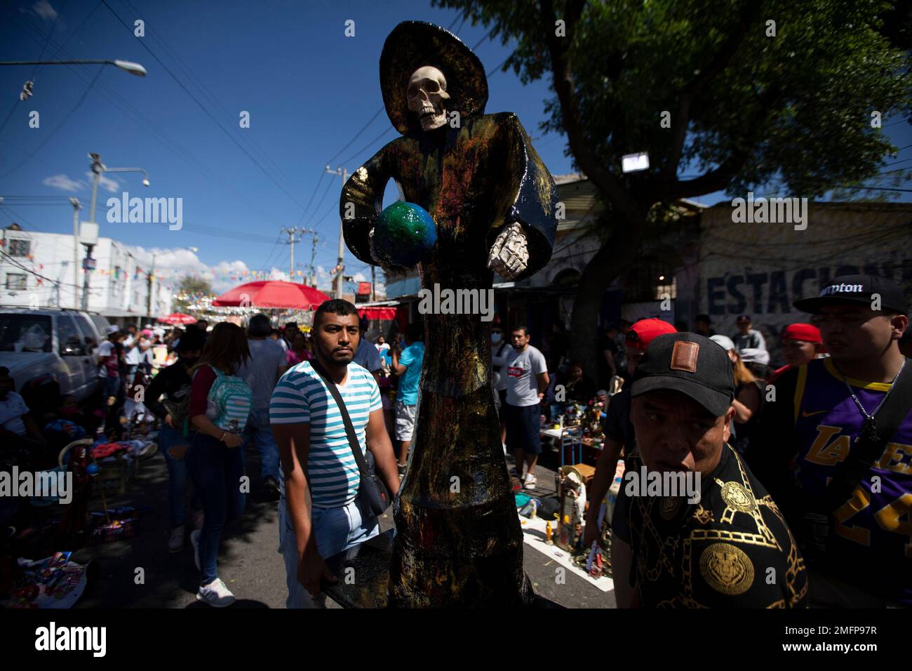 Devotees carry a huge ornately decorated statue of the "Santa Muerte ...