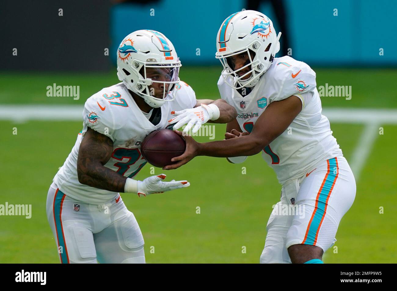 Miami Dolphins quarterback Tua Tagovailoa (1) hands the ball to running ...