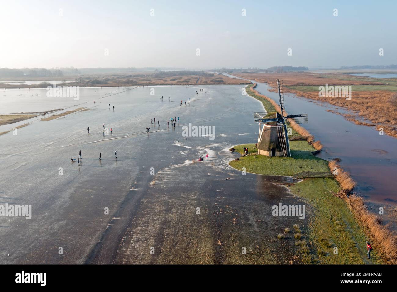Aerial from ice skating at the Ipey windmill in Friesland the ...