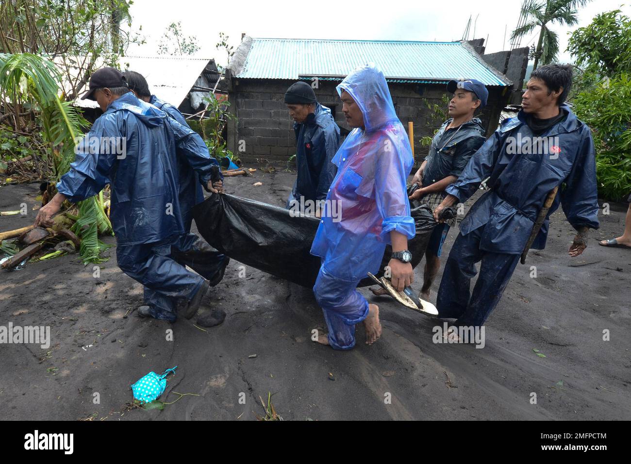 Rescuers carry the body of a man that drowned in floods as Typhoon Goni ...