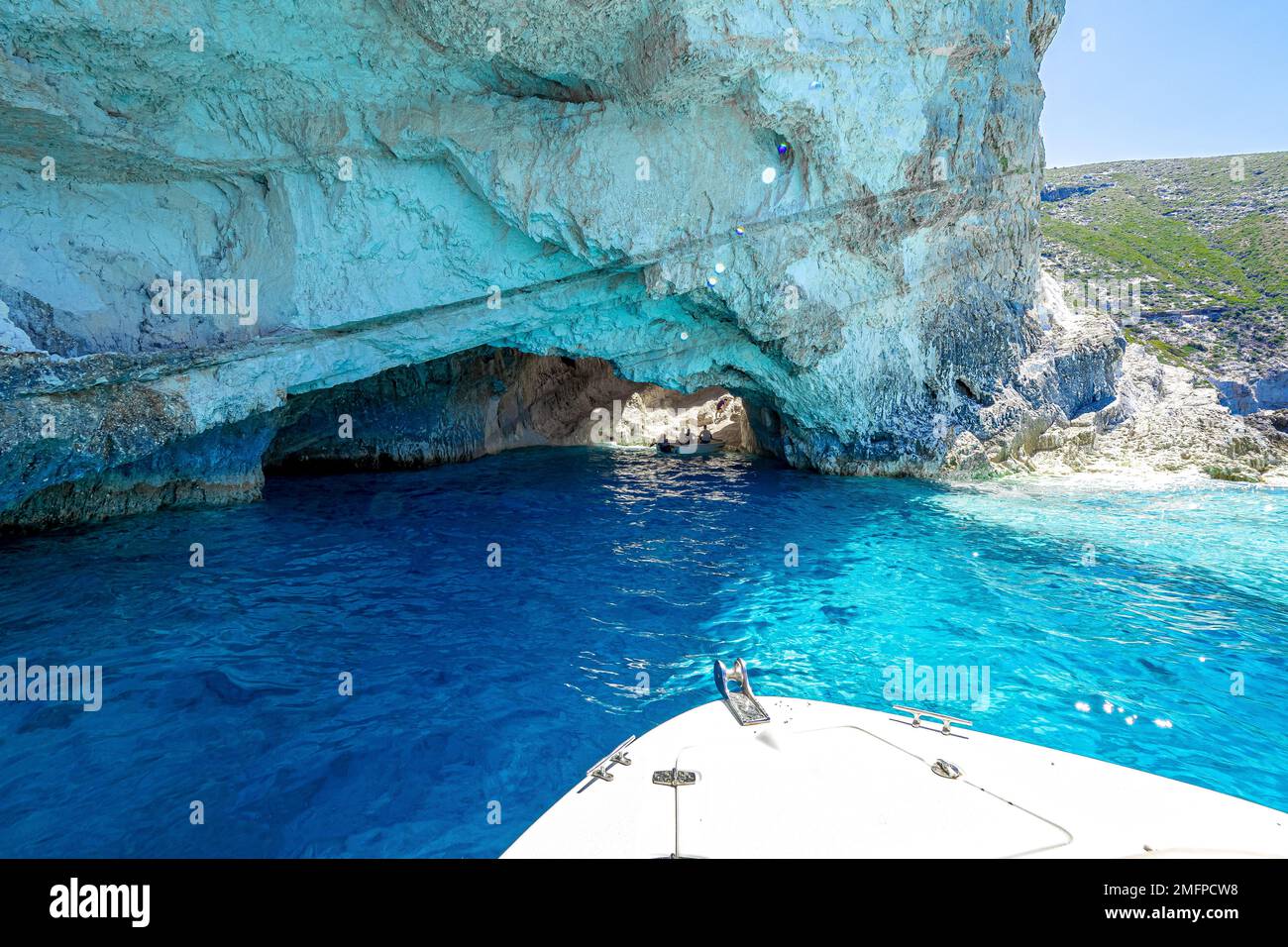 Tourists on an excursion boat explore the inside of a sea grotto ...