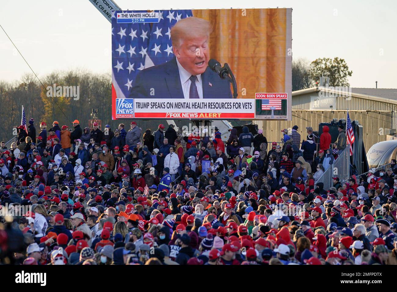 A throng of supporters listen to a video message as they await ...