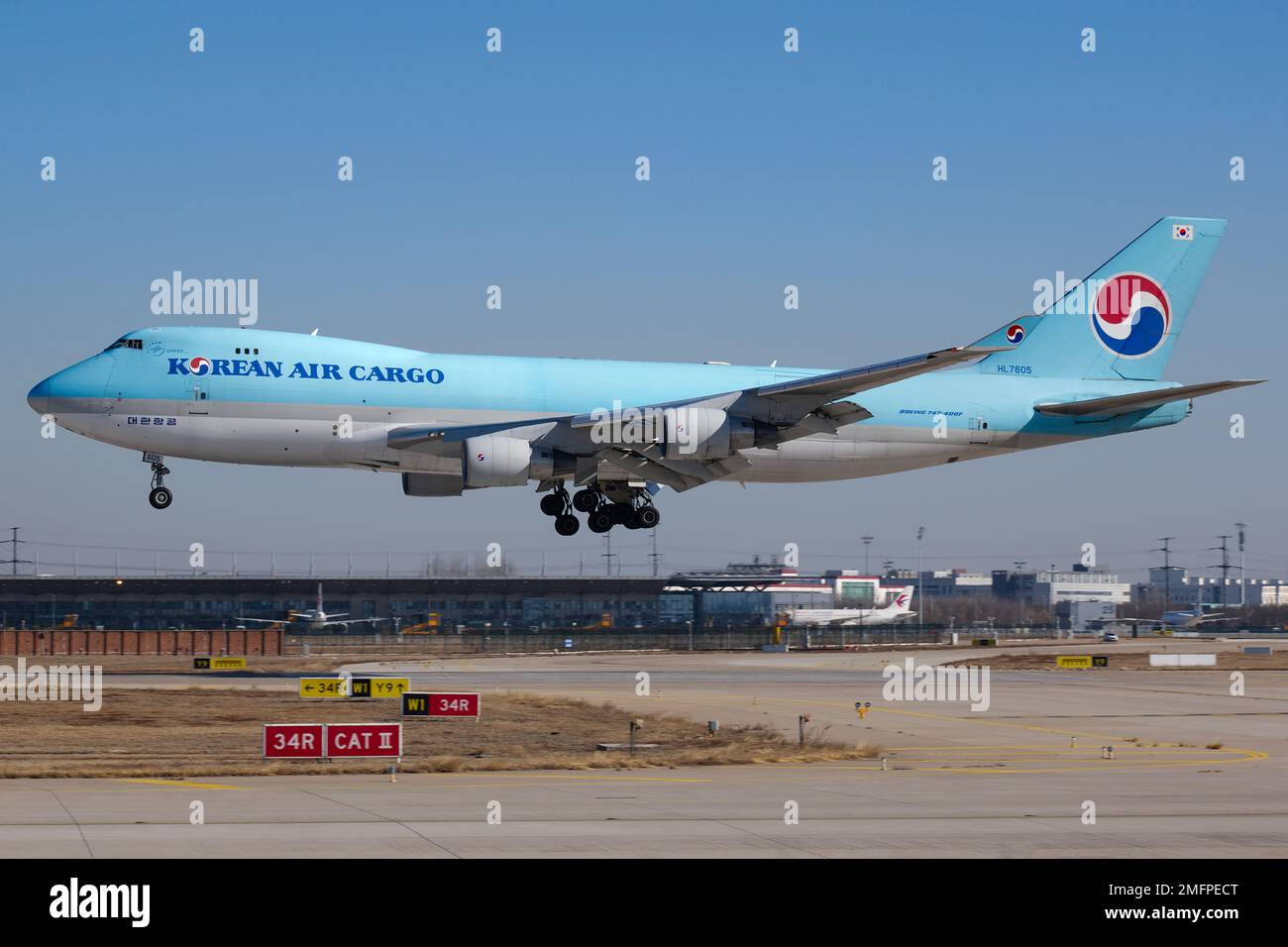 An airplane landing on a runway against a blue sky in Tianjin, China ...