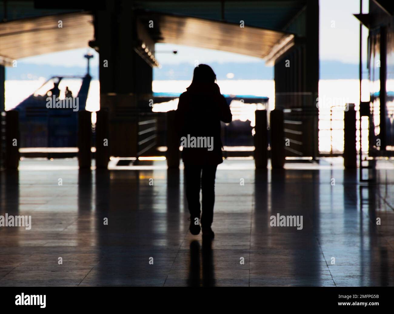 Woman in silhouette strolls inside the Lisbon train station Stock Photo ...