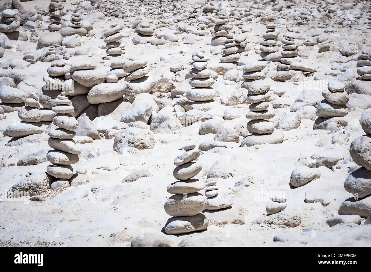 View of hundreds of cairns, stacks of balanced white round stones, on ...