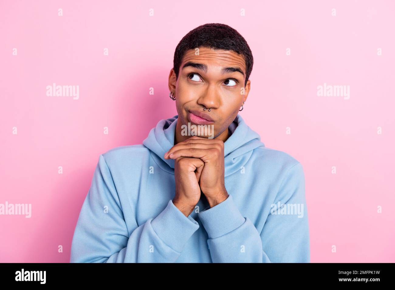 Photo of funny minded guy pouty lips hands together looking empty space ...