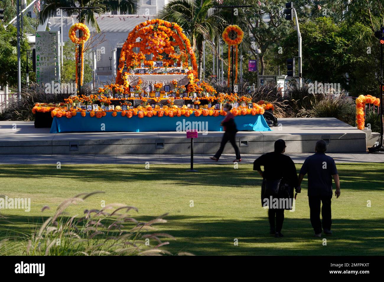 People look at a community altar decorated with marigolds, sometimes ...