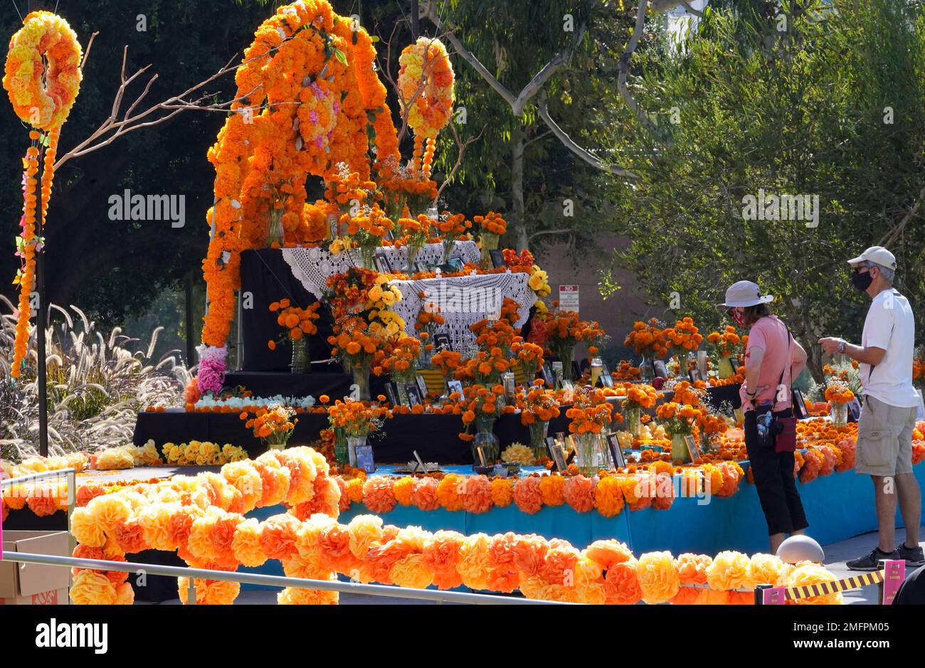 People look at a community altar decorated with marigolds, sometimes ...