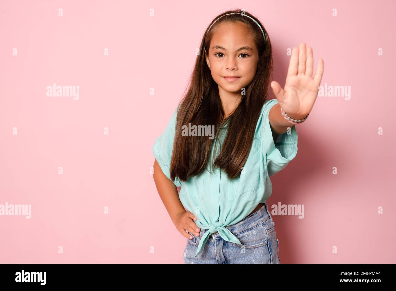 Brunette hispanic girl doing stop sing with palm of the hand. Warning ...