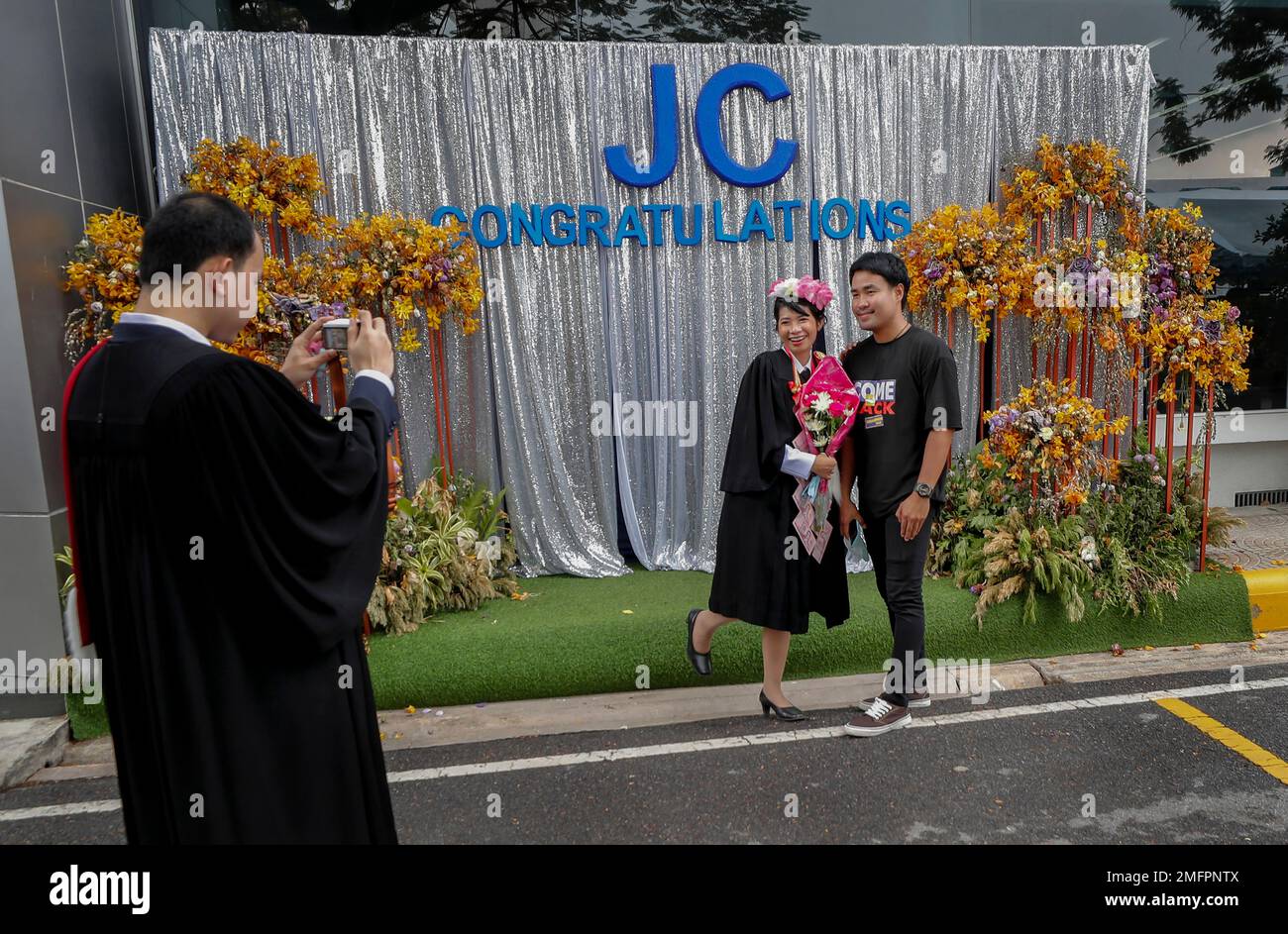A university student poses for a photo ahead of a graduation ceremony ...