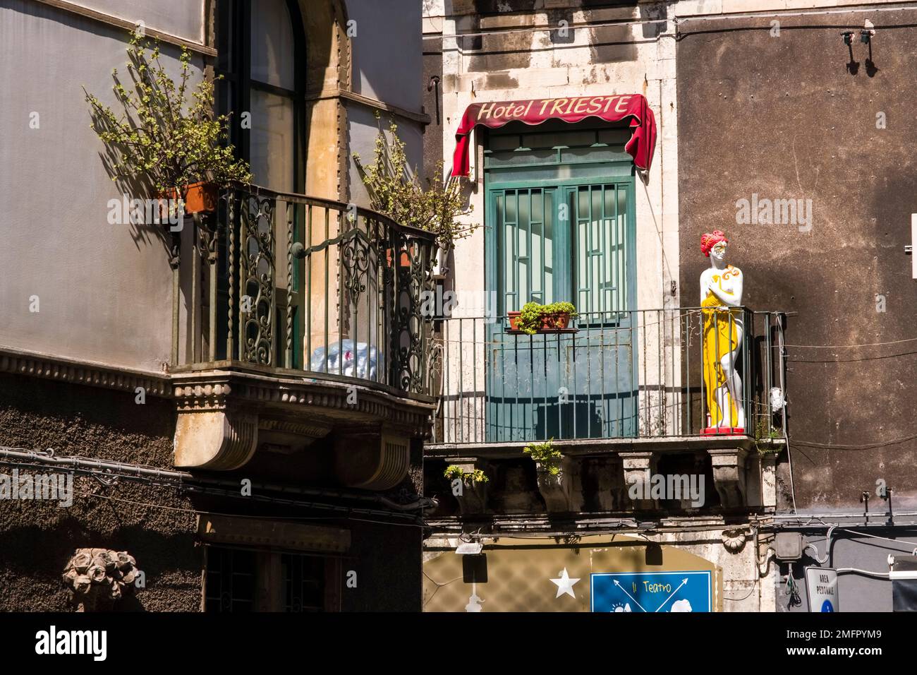 Facade of houses with balconies, green plants in pots and an artfully ...