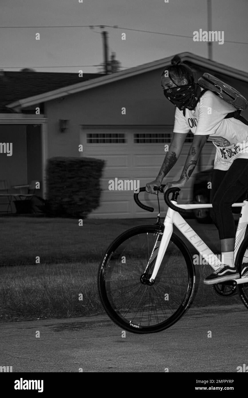 A greyscale shot of a man riding a bicycle Stock Photo - Alamy